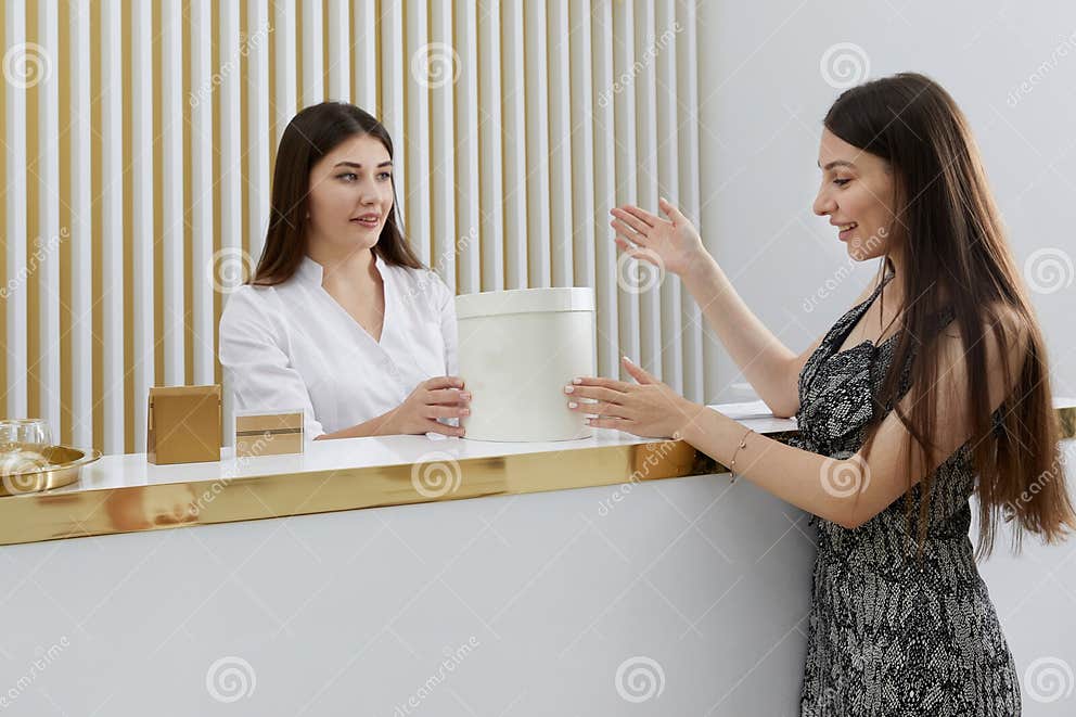 Female Receptionist at Reception Desk with a Client in a Modern Office ...