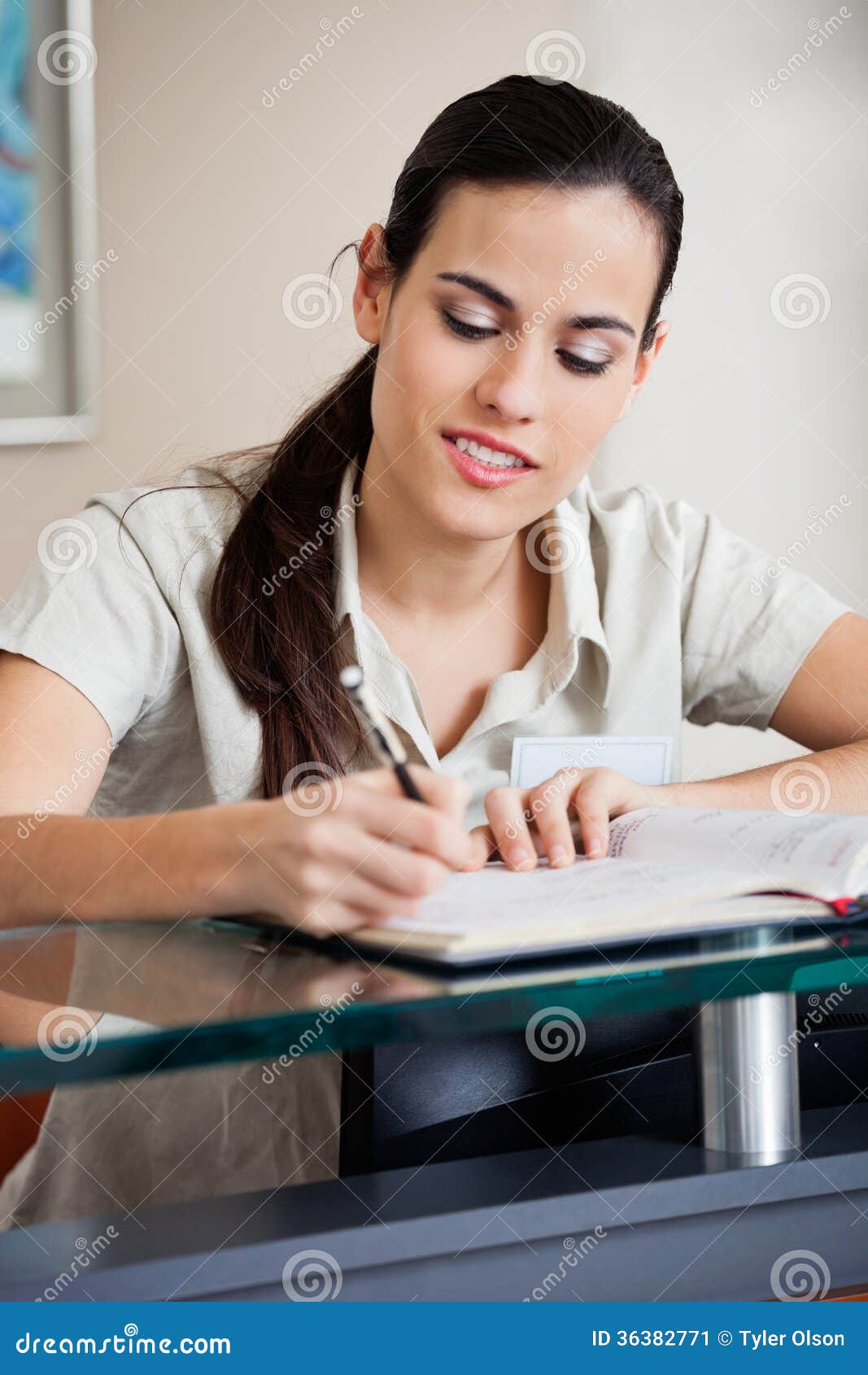 Female Receptionist Writing in Book Stock Image - Image of assistant ...