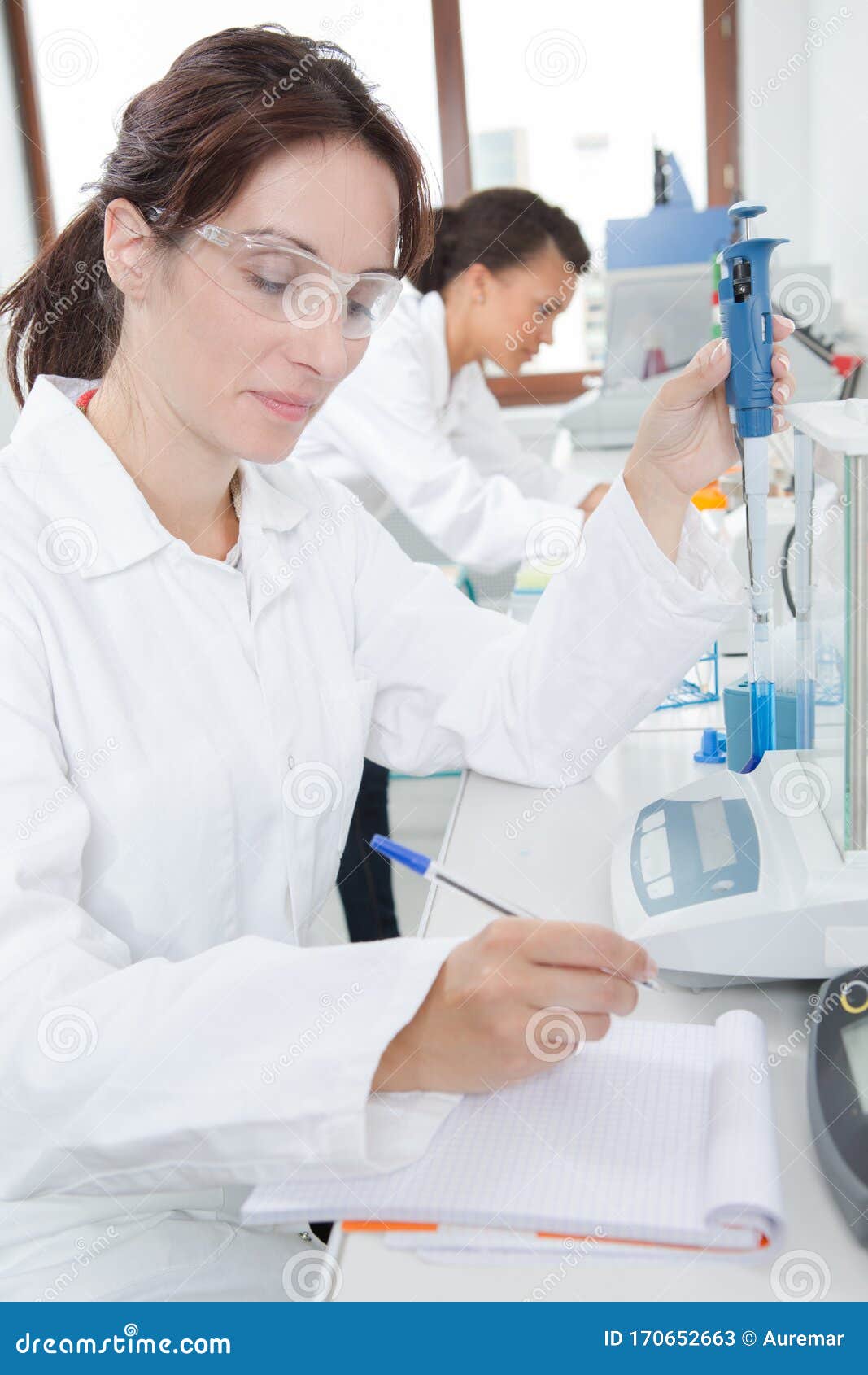 Female Researcher Recording Experiment in Notebook Stock Image - Image ...