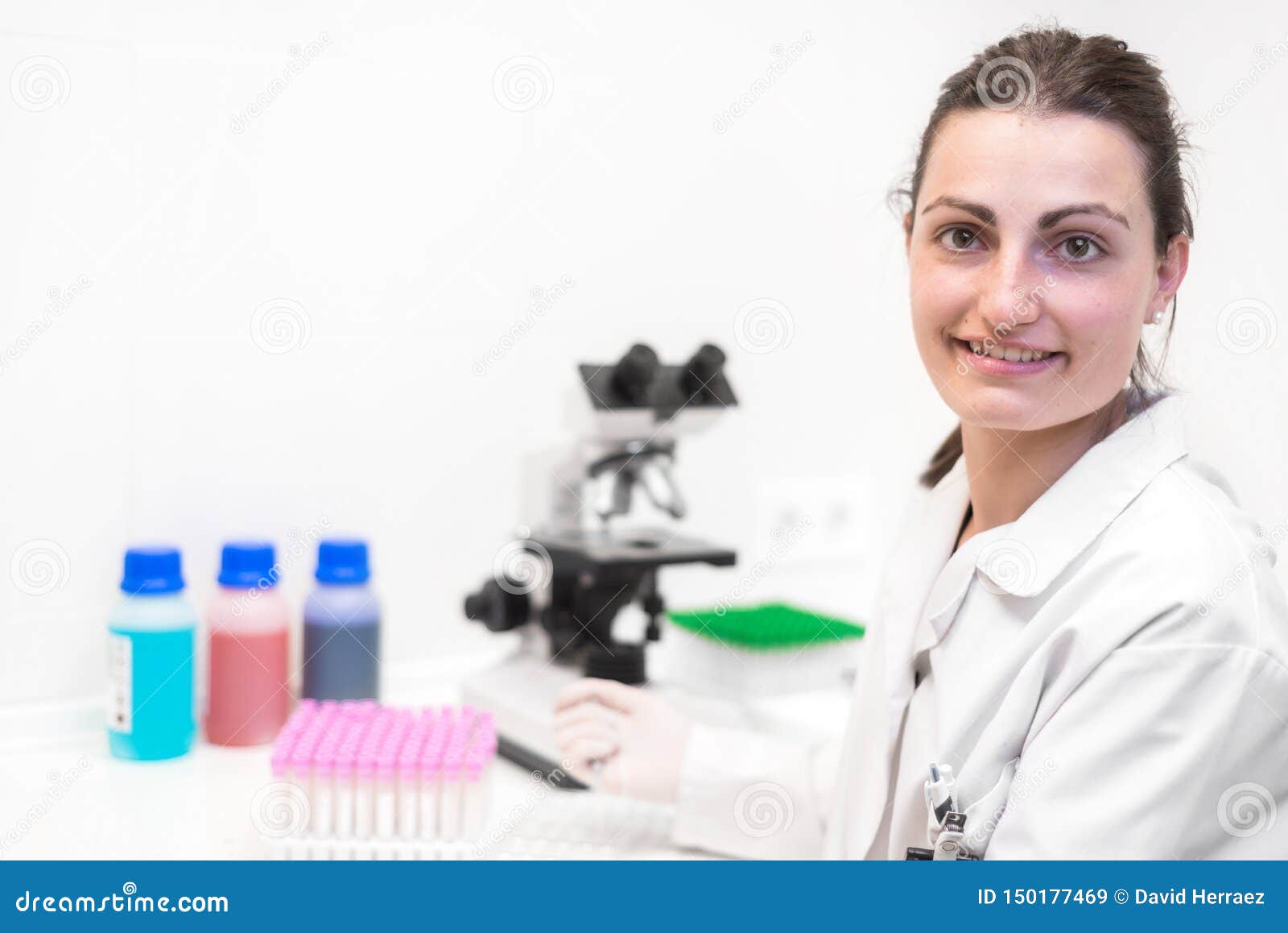 Female Researcher Smiling. Female Researcher Using Microscope and ...