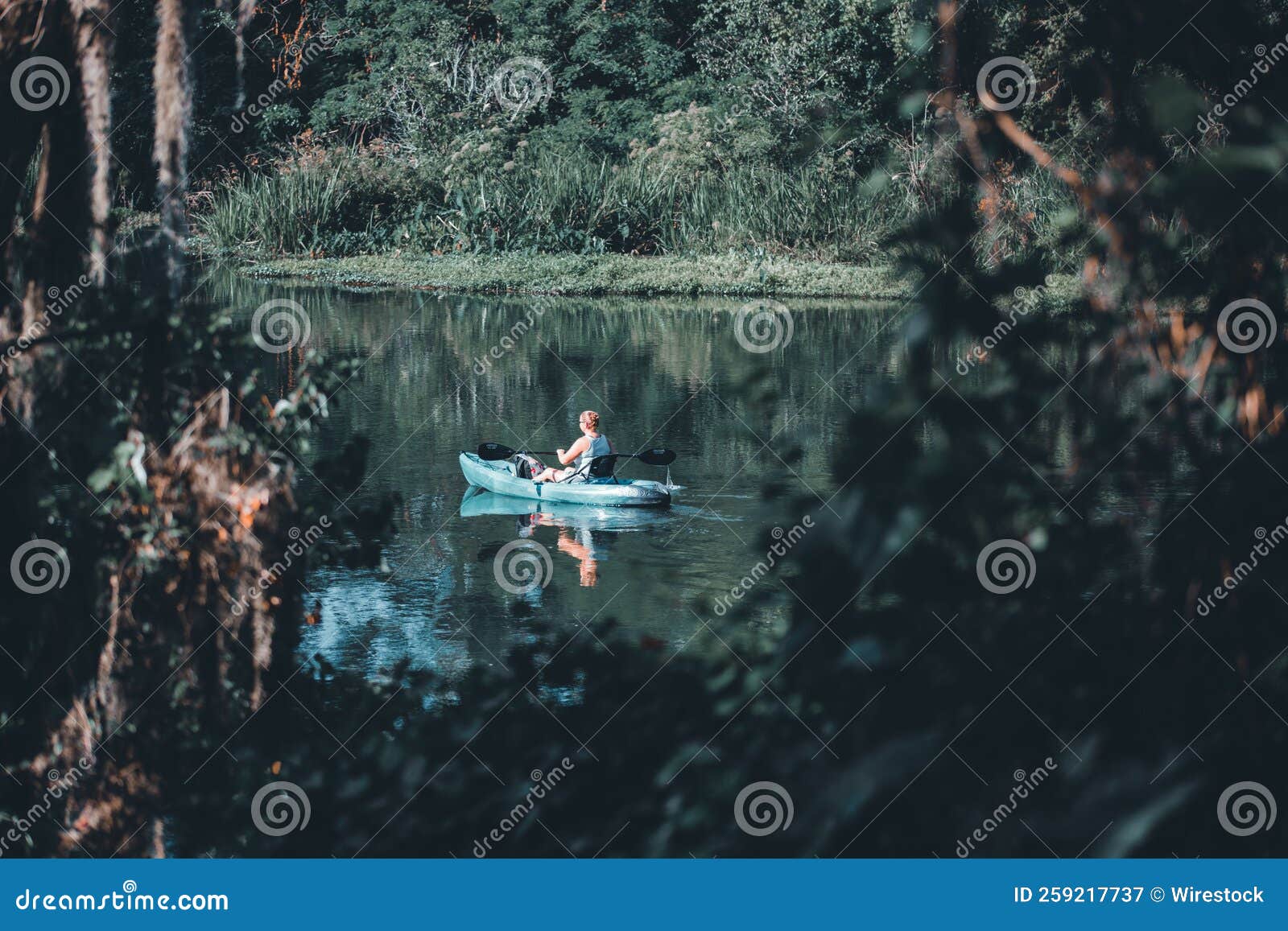 Female Riding a Boat in a Lake with the Reflection of the Forest Stock ...