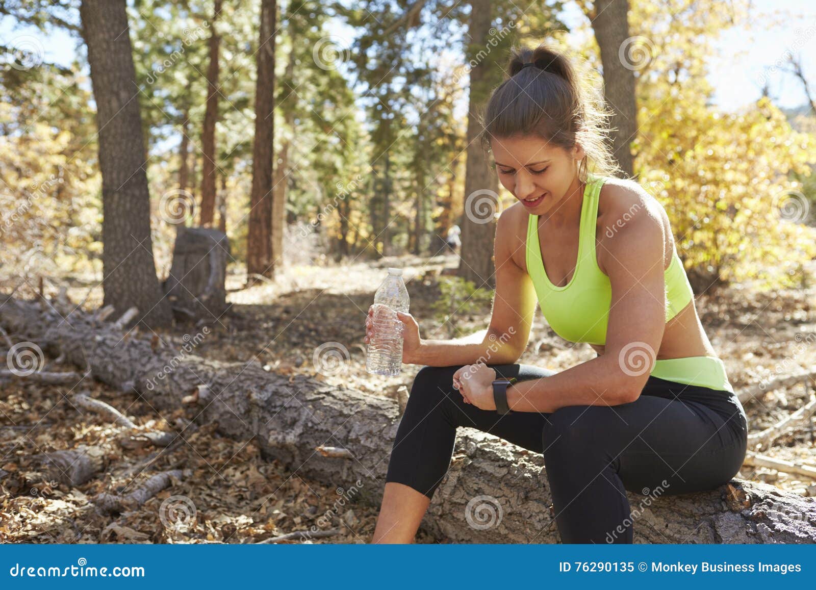 Female Runner in a Forest Sits Checking Her Smartwatch Stock Image ...