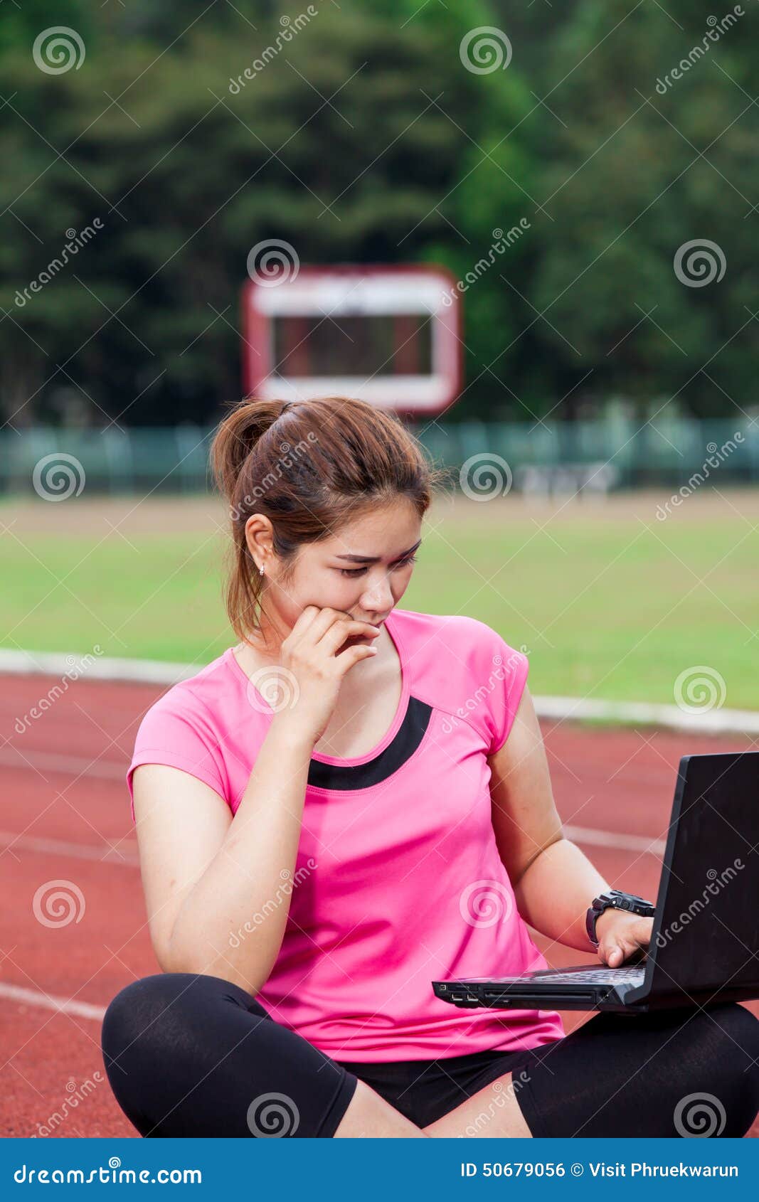 Female Runner Using Laptop Computer on the Running Track Stock Photo ...