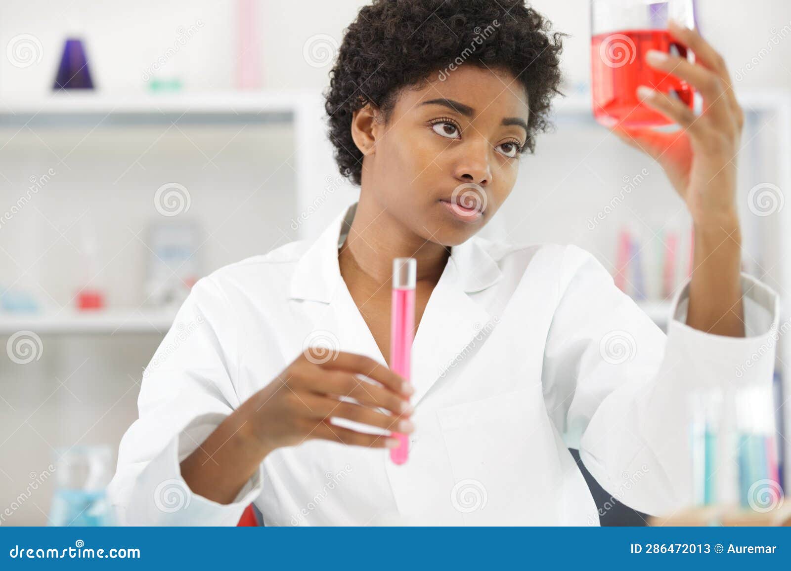 Female Scientist Holding Up Beaker To Examine Liquid Stock Image ...