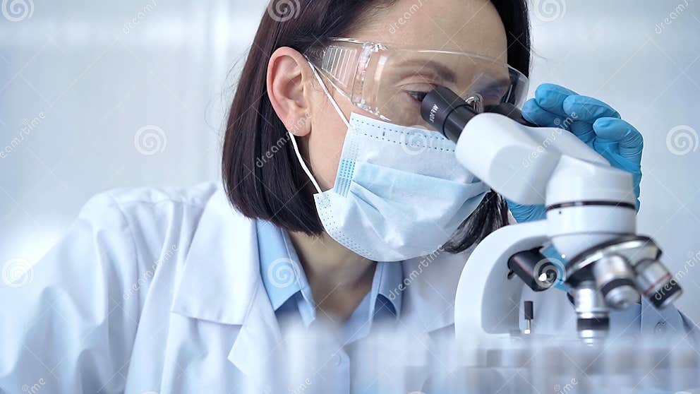Female Scientist in Lab Goggles, Protective Mask and Gloves is Using ...