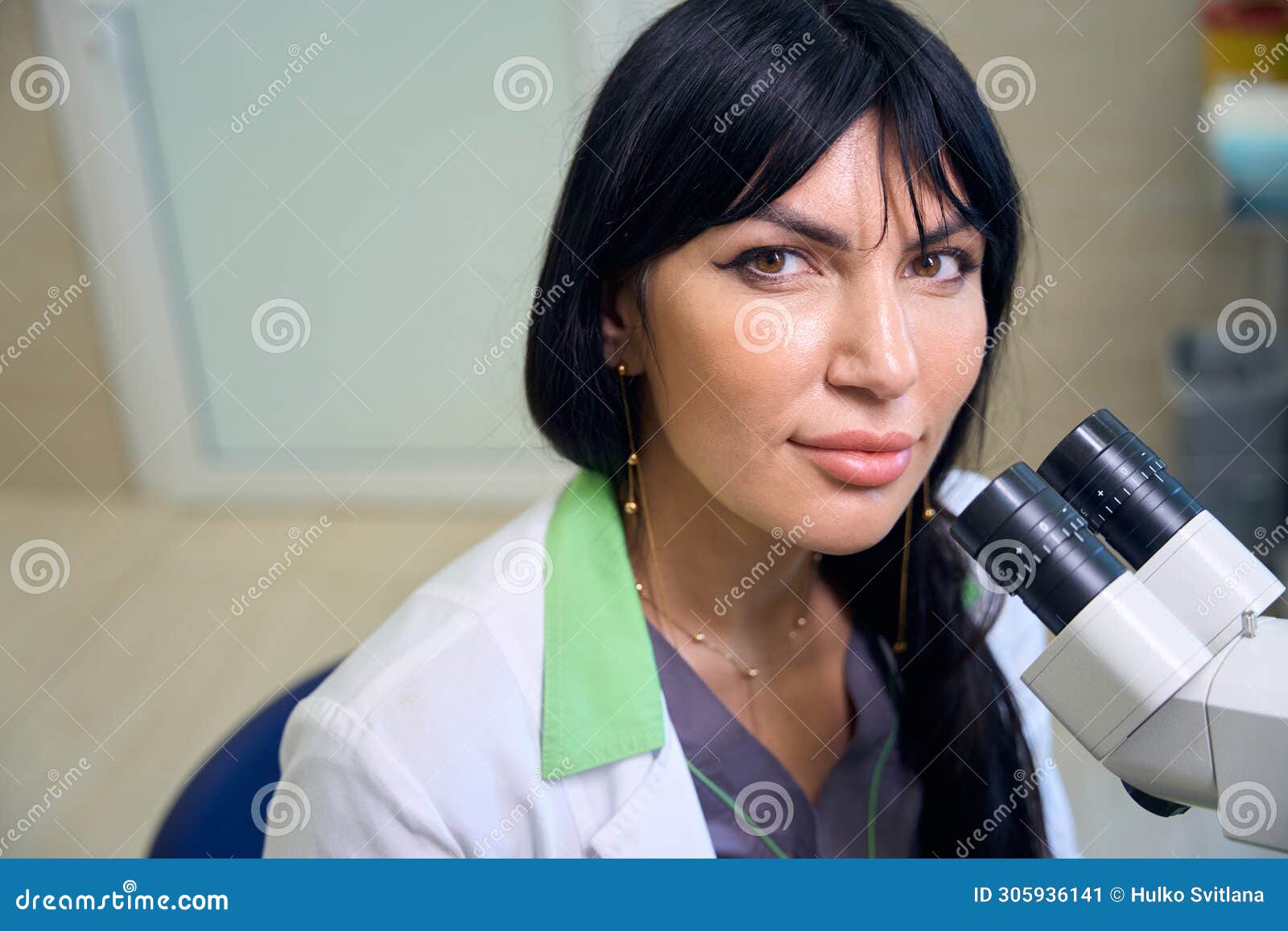 Female Scientist Looking At Camera During Working With Microscope In Laboratory Stock Image