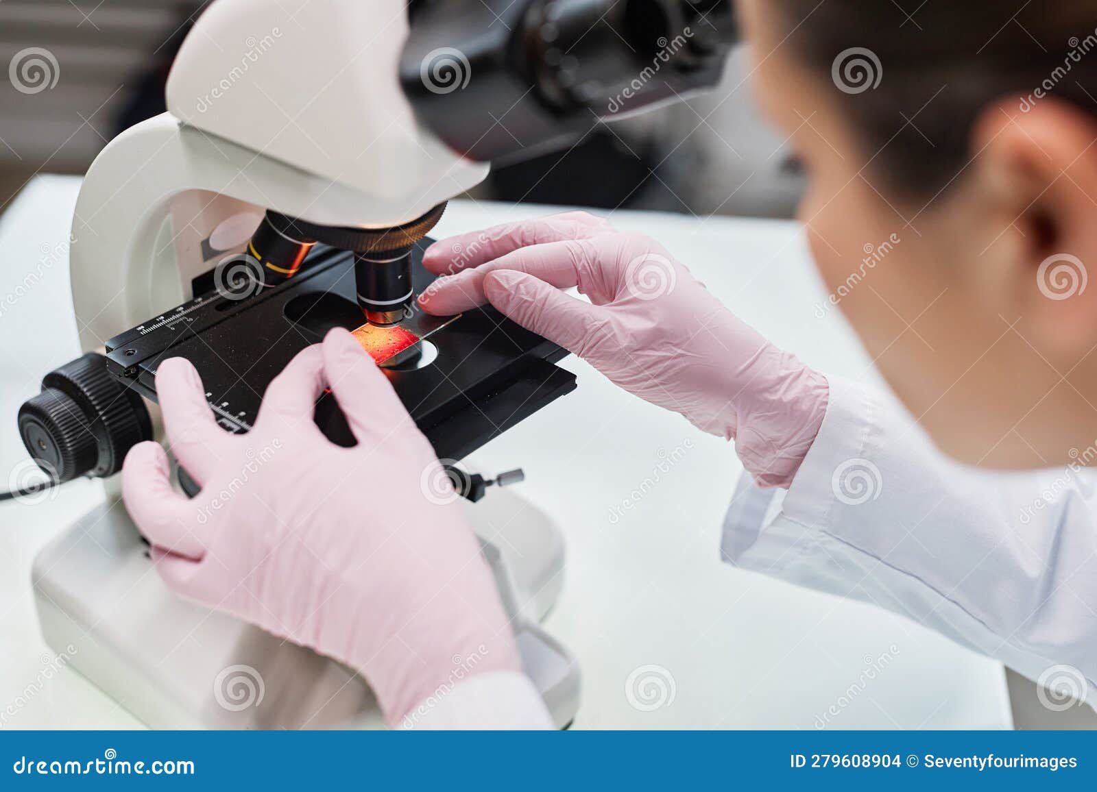 Female Scientist Putting Test Material in Microscope in Laboratory ...