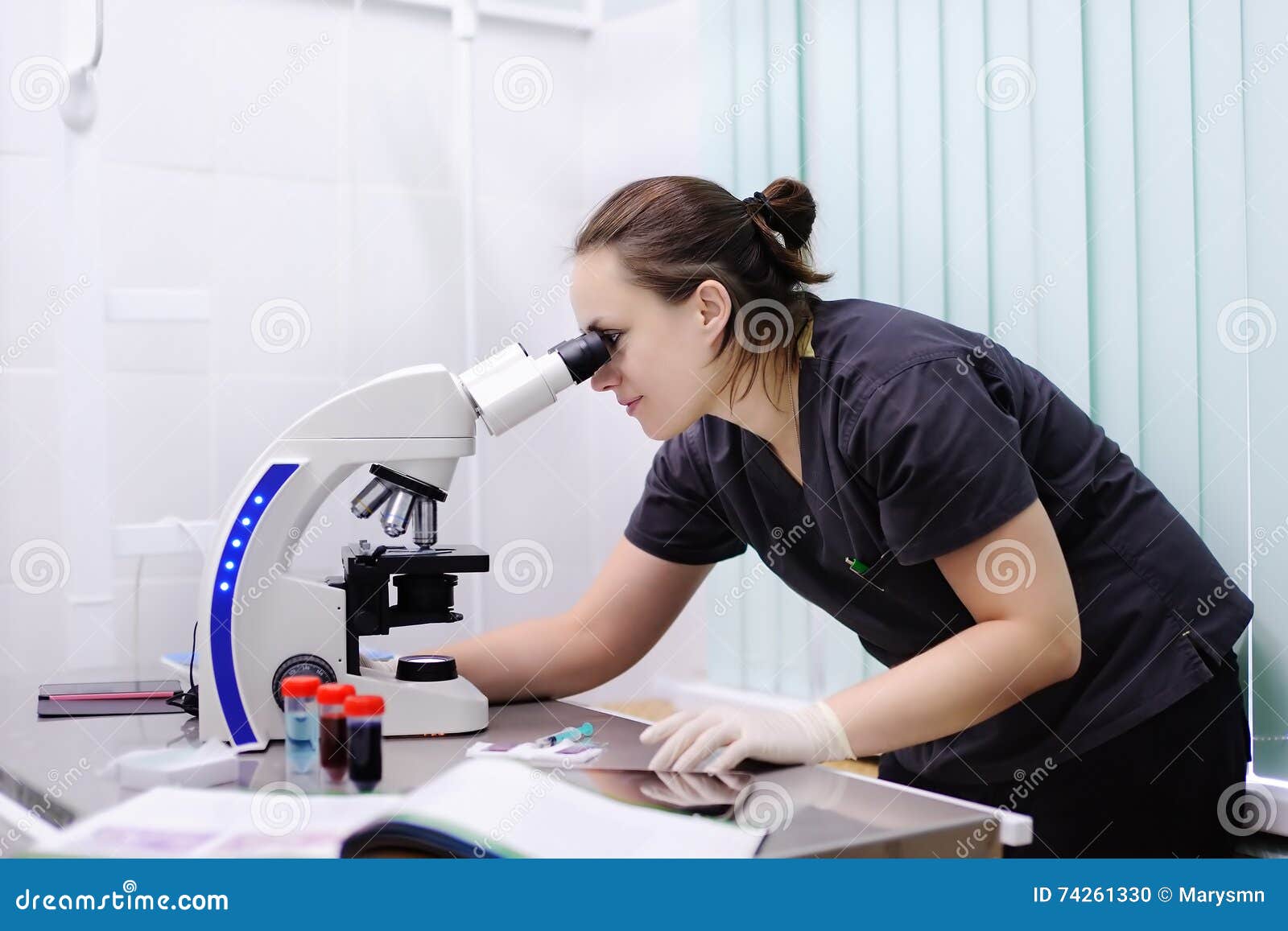 Female Scientist Studying New Substance or Virus in Microscope Stock ...