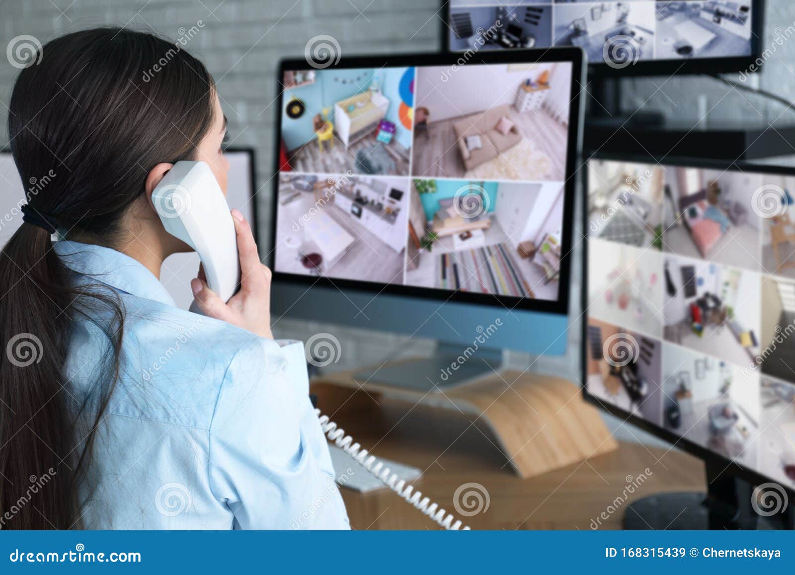 Female Security Guard Talking by Telephone Near Monitors at Workplace ...