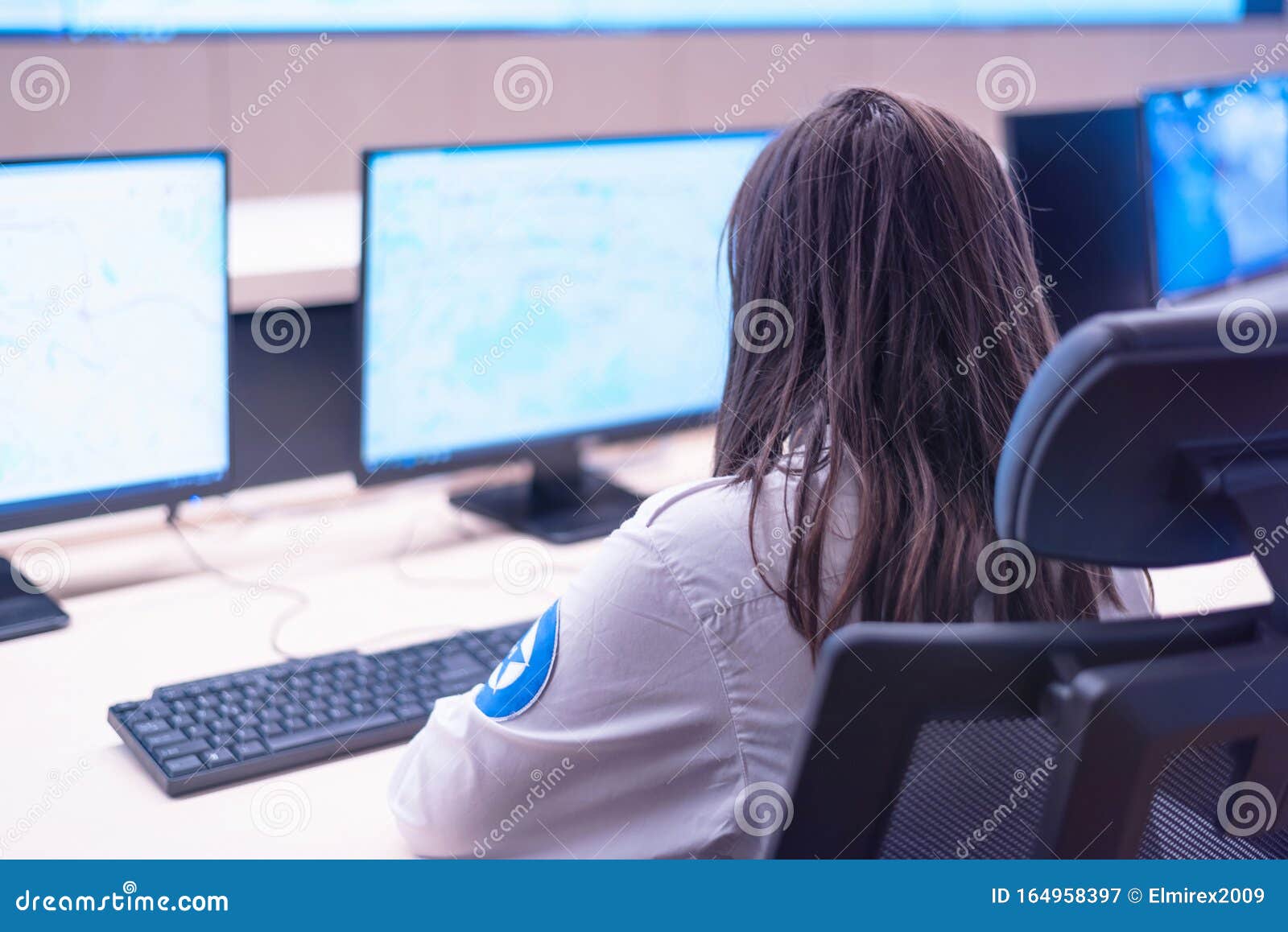 Female Security Guard Working on Computers while Sitting in the Main ...