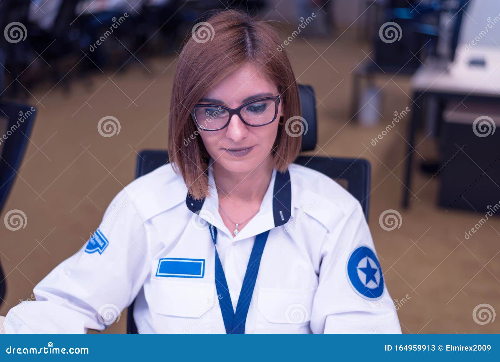 Female Security Guard Working on Computers while Sitting in the Main ...