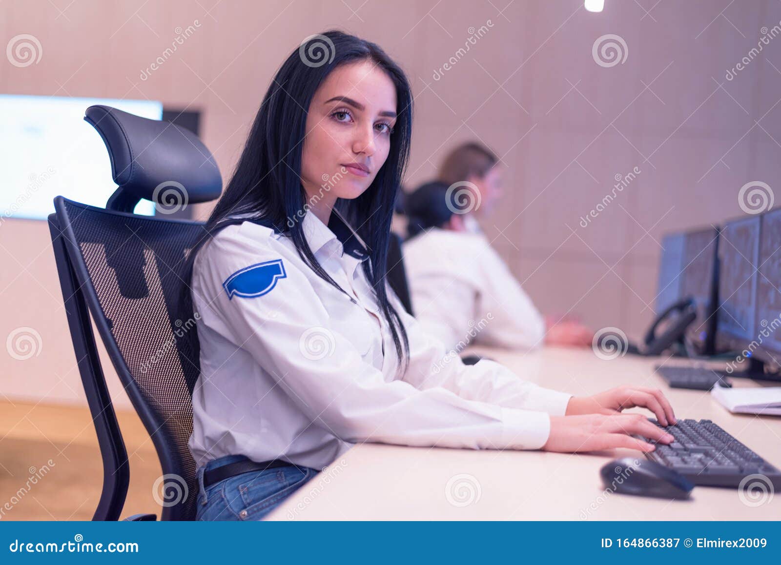 Female Security Guard Working on Computers while Sitting in the Main ...