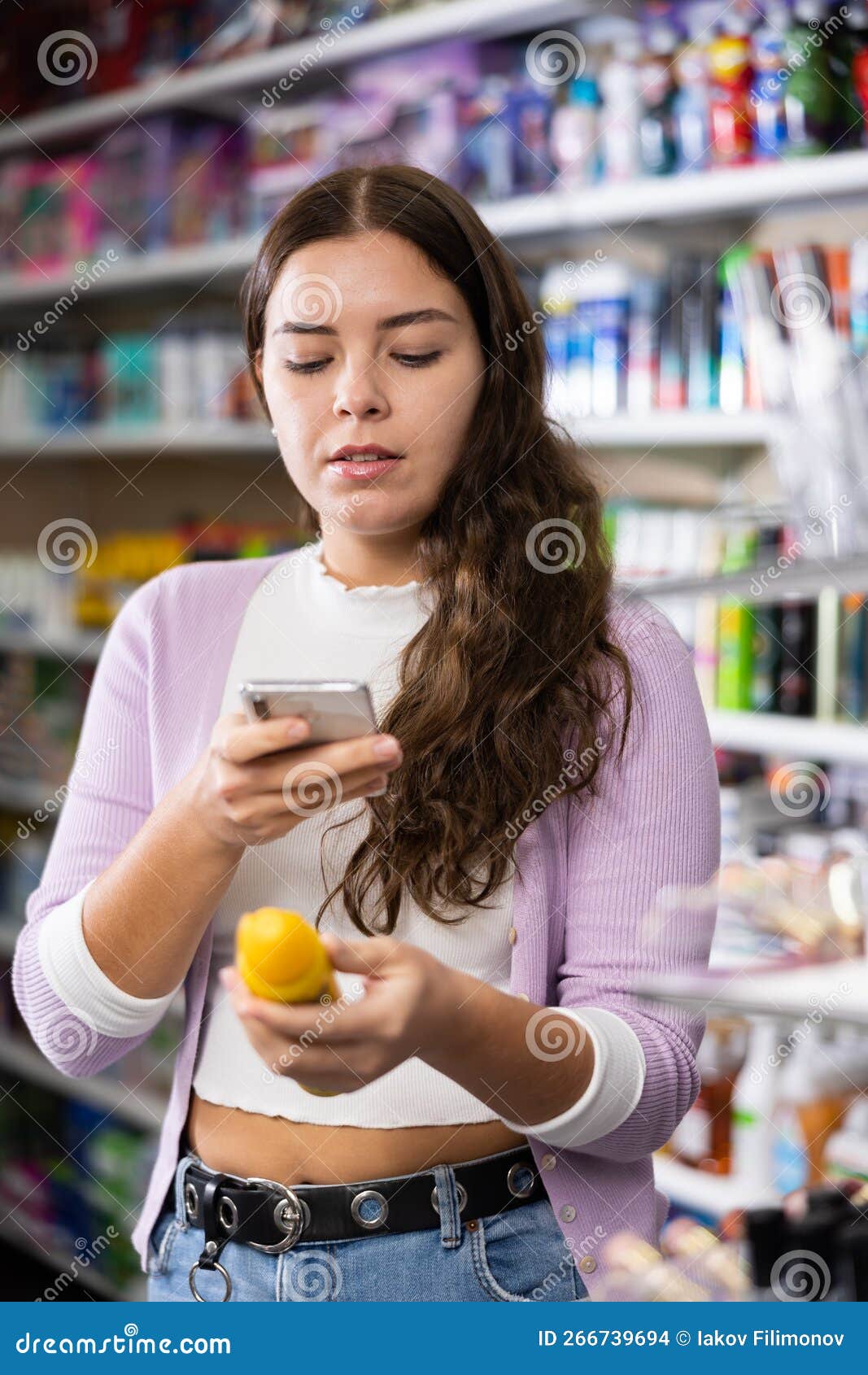 Female Shopper Scanning a QR Code Using a Mobile Phone in Cosmetics ...