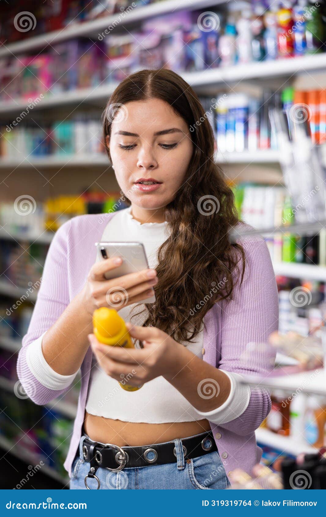 Female Shopper Scanning a QR Code Using a Mobile Phone in Cosmetics ...