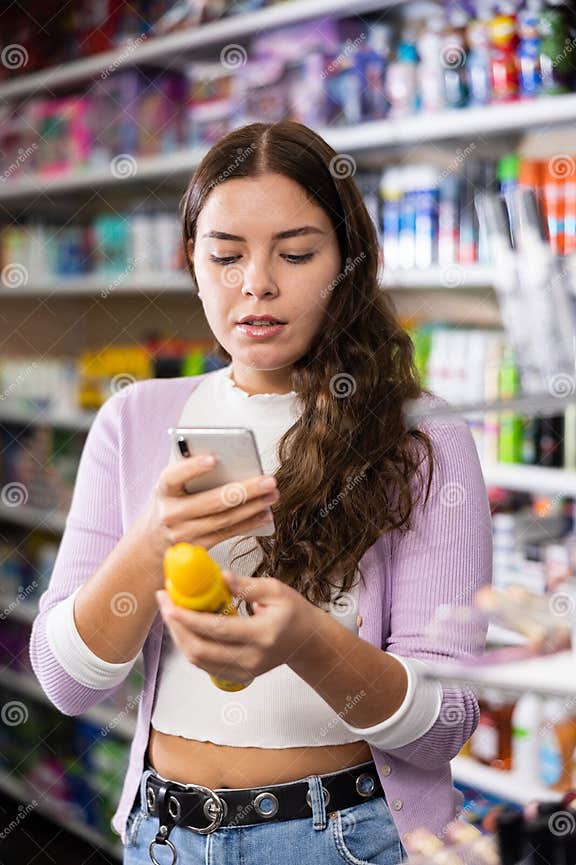 Female Shopper Scanning a QR Code Using a Mobile Phone in Cosmetics ...