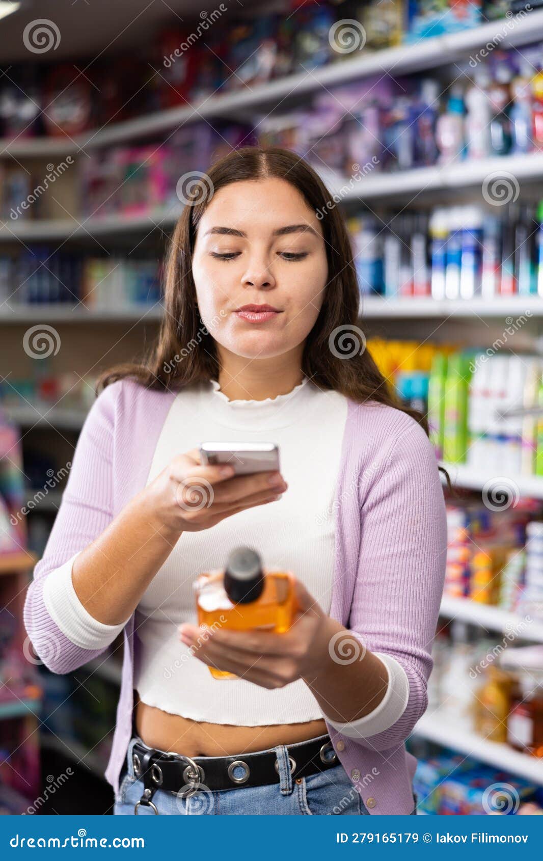 Female Shopper Scanning a QR Code Using a Mobile Phone in Cosmetics ...