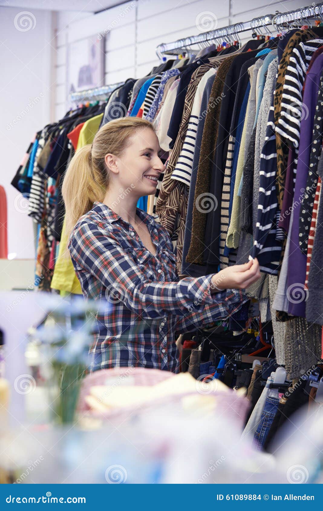 Female Shopper in Thrift Store Looking at Clothes Stock Photo - Image ...