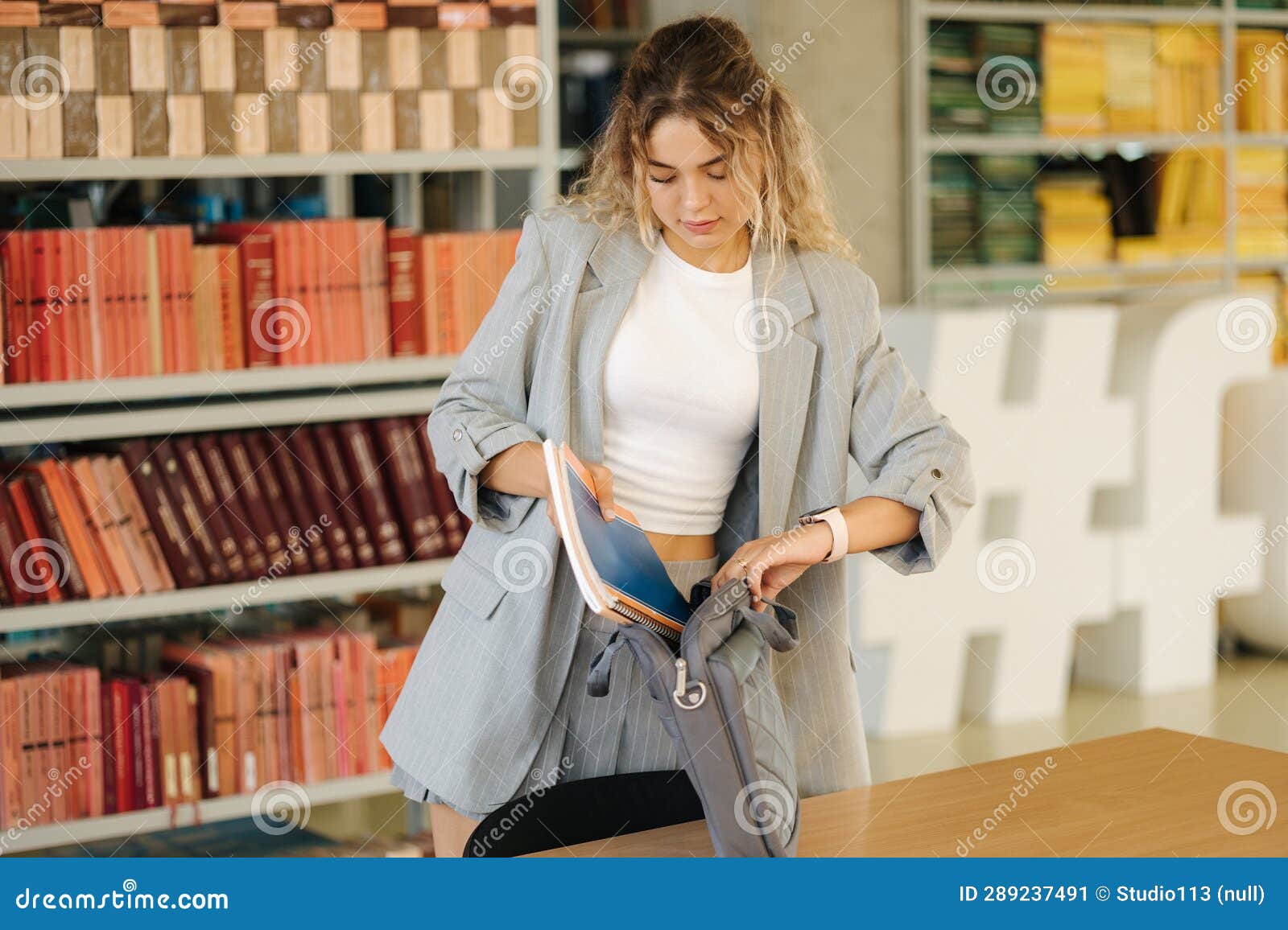 Female Student Finish Study in Public Library and Puts Notebook in the ...