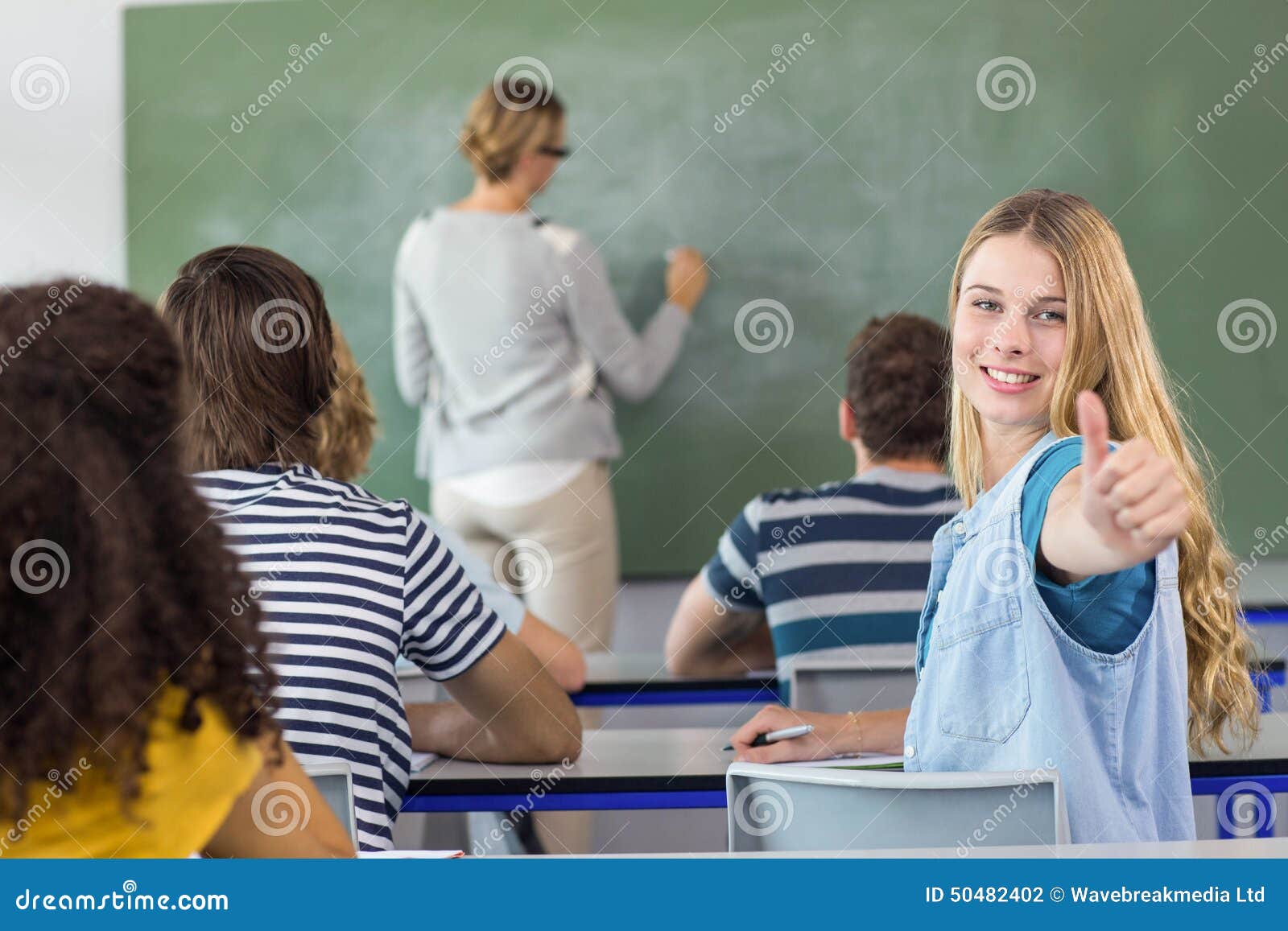 Female Student Gesturing Thumbs Up in Class Stock Photo - Image of ...