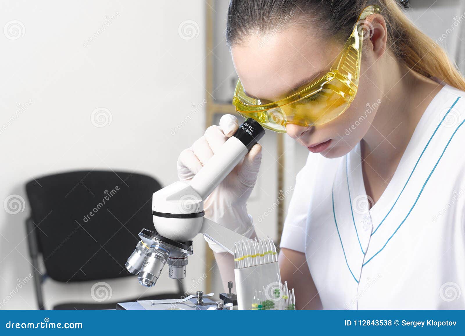 A Female Student Lab Assistant in Protective Glasses Works with Stock ...