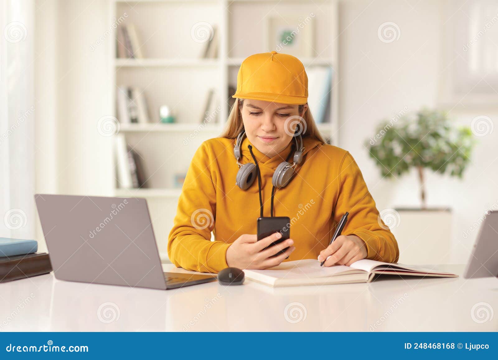 Female Student with a Laptop Computer and a Mobile Phone Sitting at ...