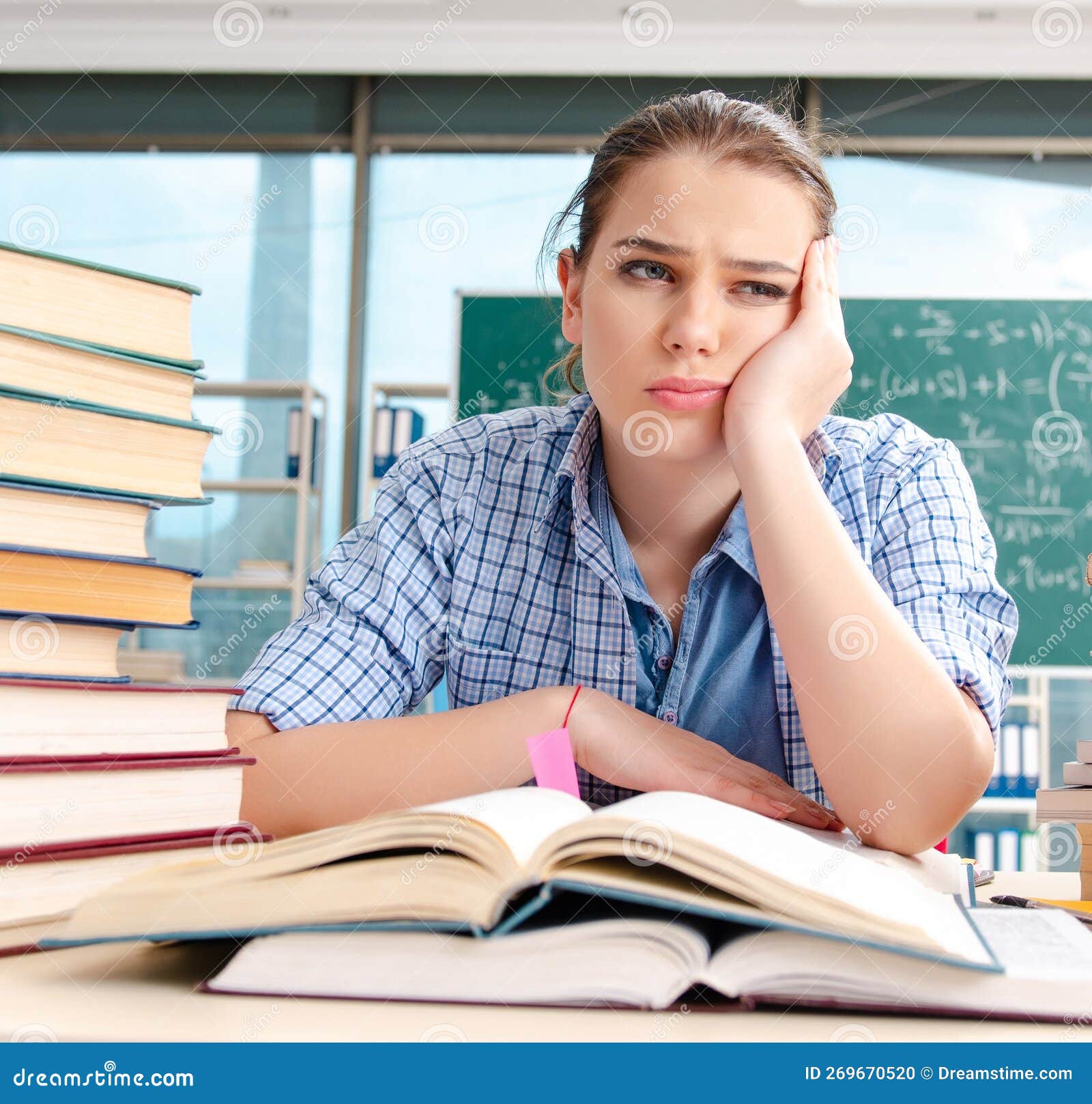 Female Student with Many Books Sitting in the Classroom Stock Photo ...