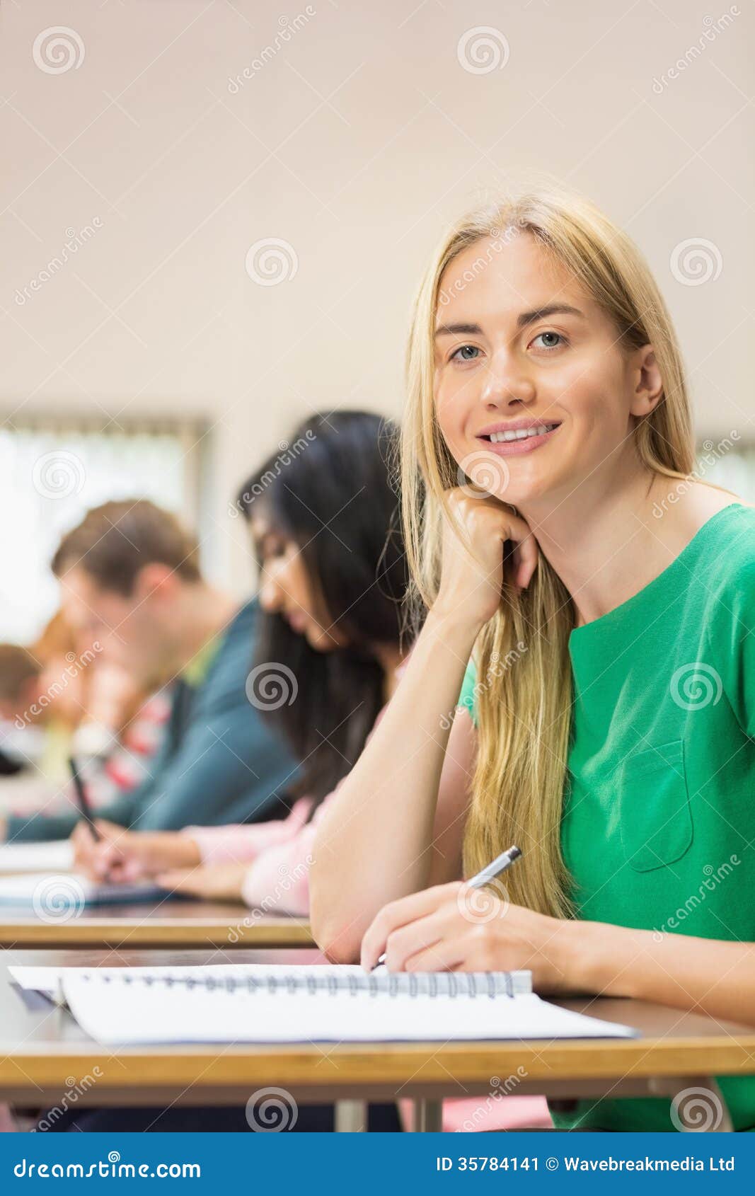 Female Student with Others Writing Notes in Classroom Stock Image ...