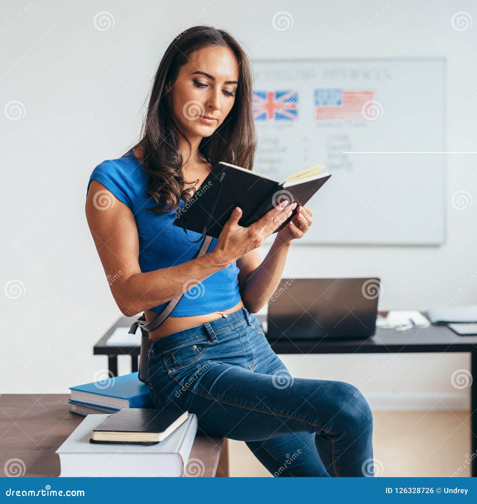 Female Student Sitting at Table Reading Book. Stock Photo - Image of ...