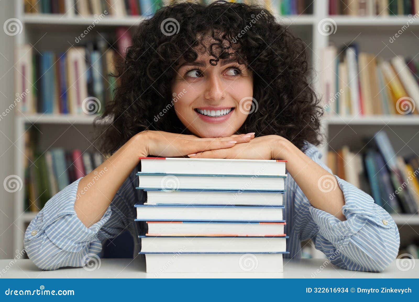 Female Student with Stack of Books Sitting at Table in Library Stock ...
