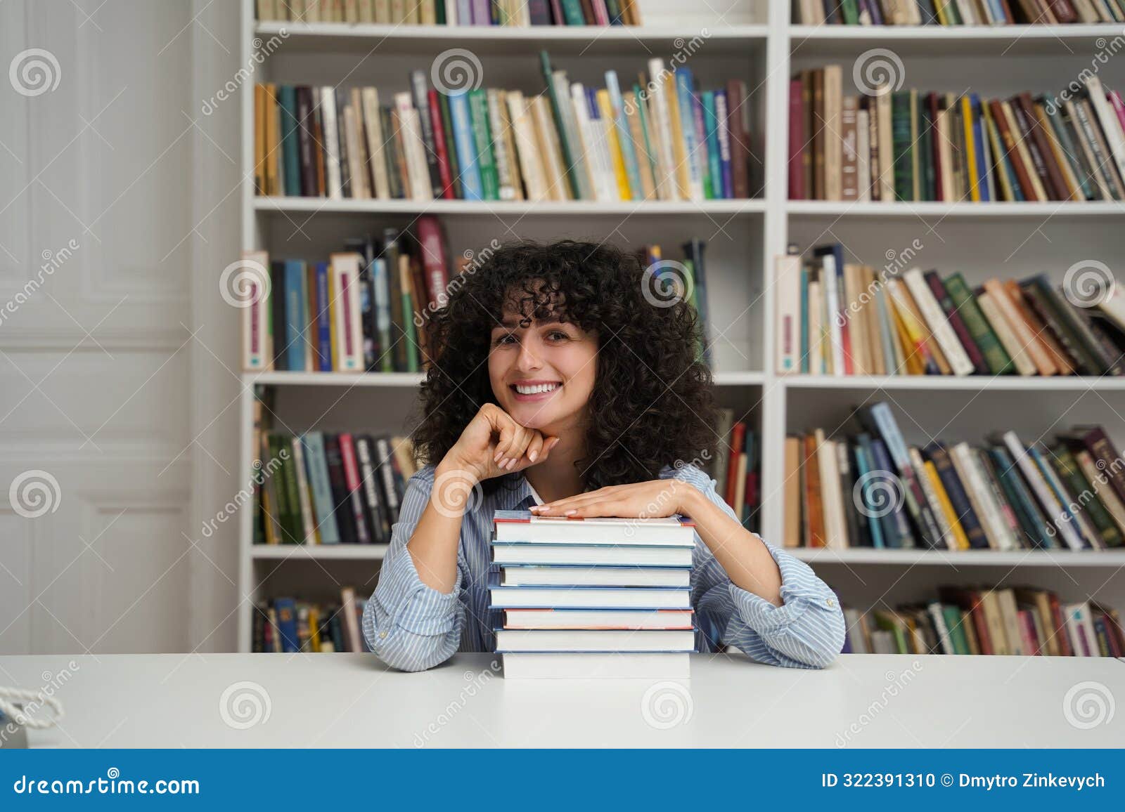 Female Student with Stack of Books Sitting at Table in Library Stock ...