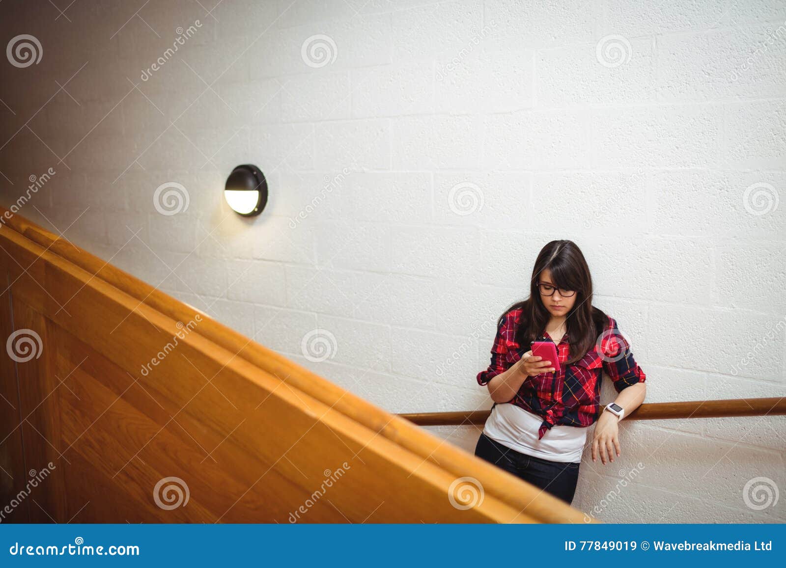 Female Student Standing on Staircase and Using Mobile Phone Stock Image ...