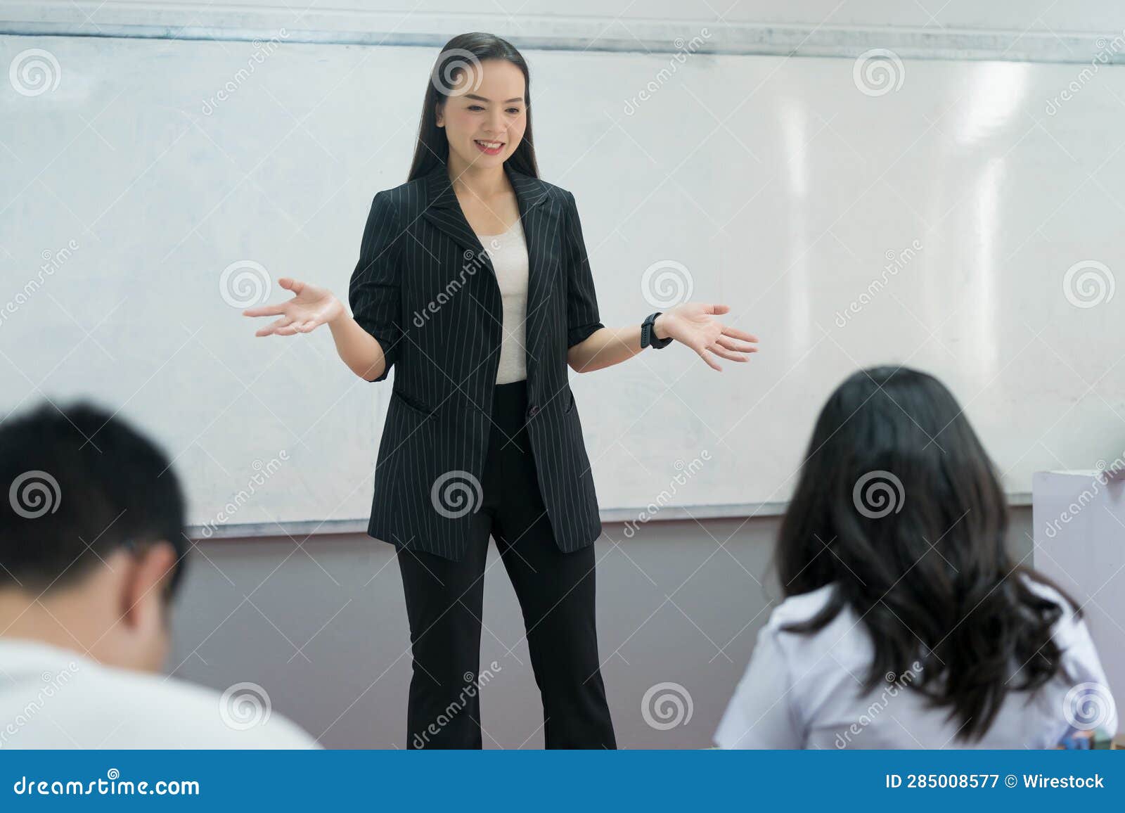 Female Student Stands in Front of a Classroom of Her Peers Delivering a ...