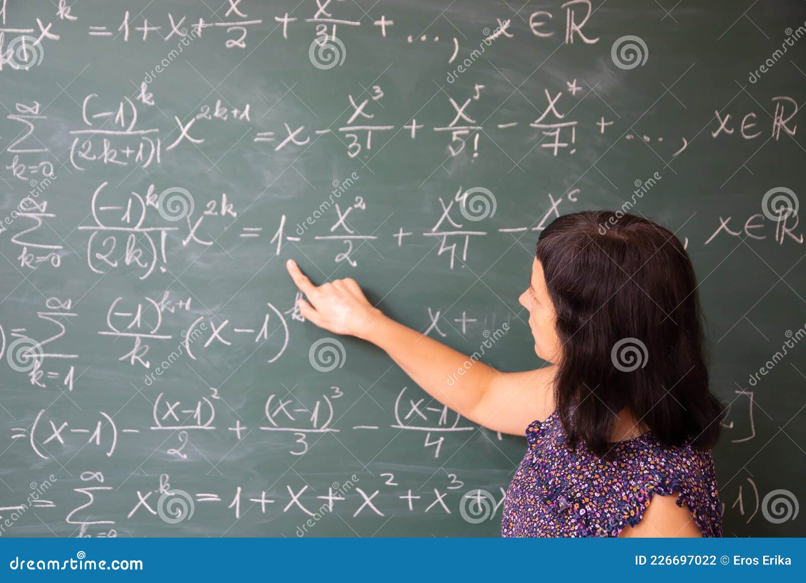 Female Student Or Teacher In The Classroom Writing On Chalkboard ...
