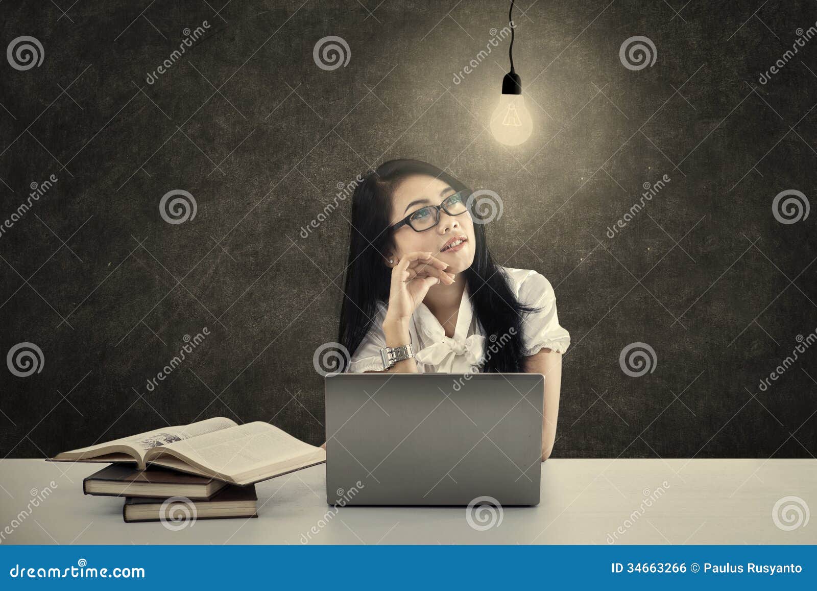 Female Student Thinking Under a Lit Bulb Stock Photo - Image of bulb ...