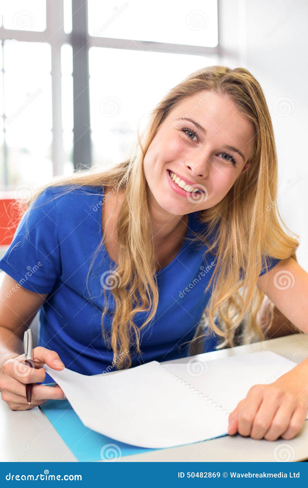 Female Student Writing Notes in Classroom Stock Image - Image of blonde ...