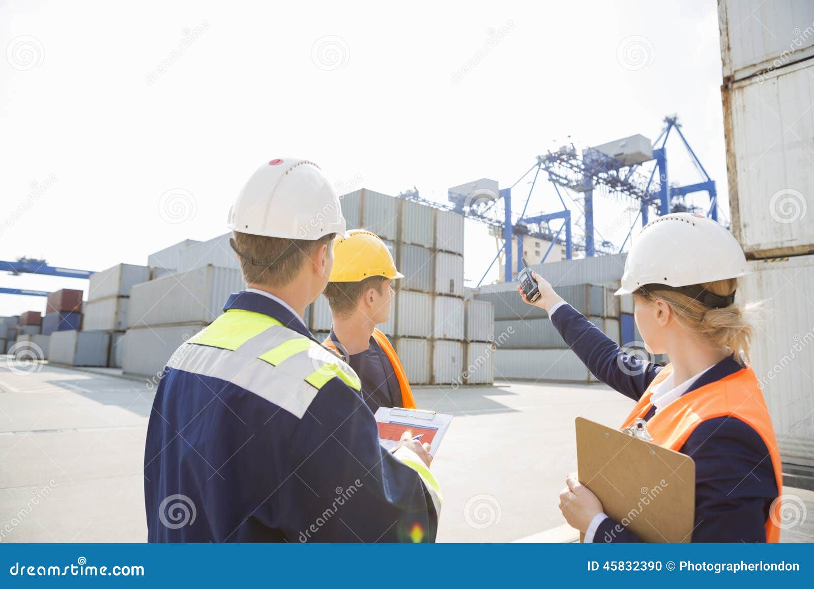 Female Supervisor Discussing With Workers In Shipping Yard Stock Photo ...