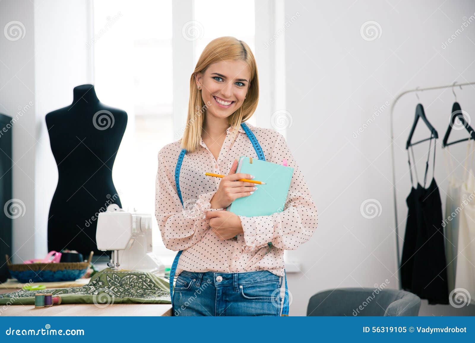 Female Tailor with Notebook and Pencil in Workshop Stock Image - Image ...