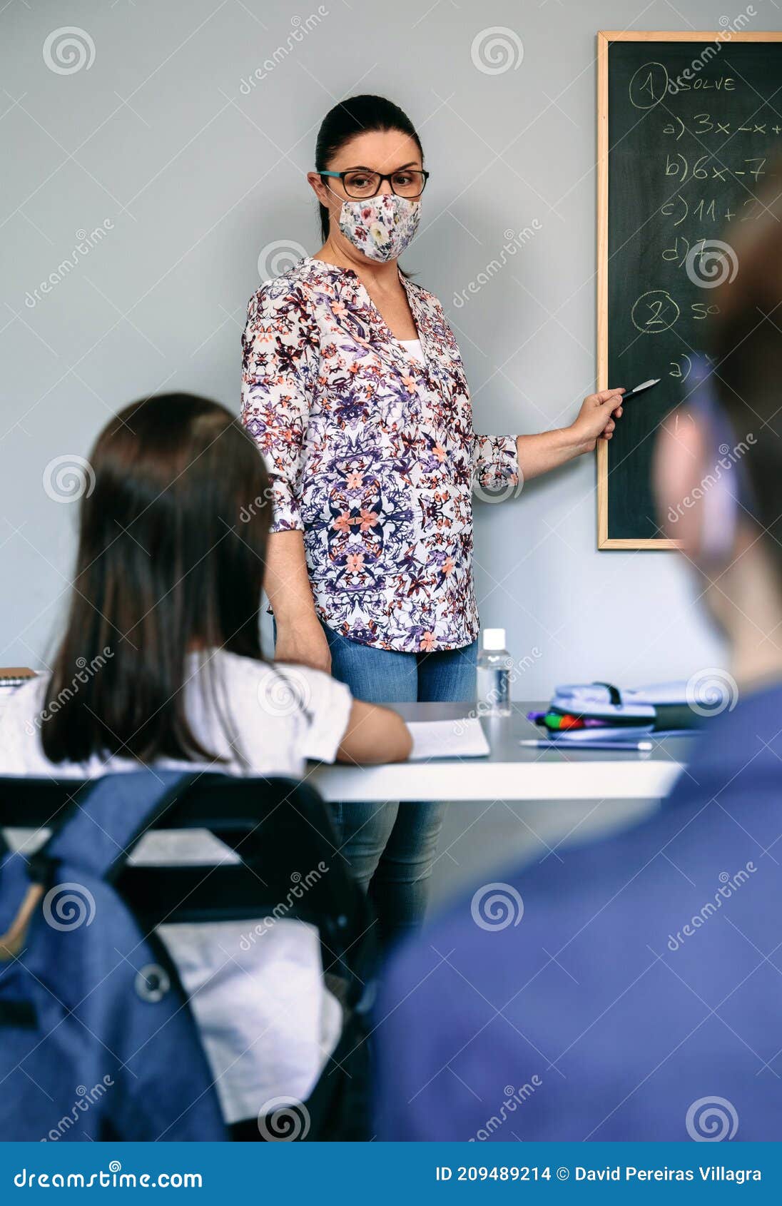Teacher with Mask Explaining Exercises in Math Class Stock Photo ...