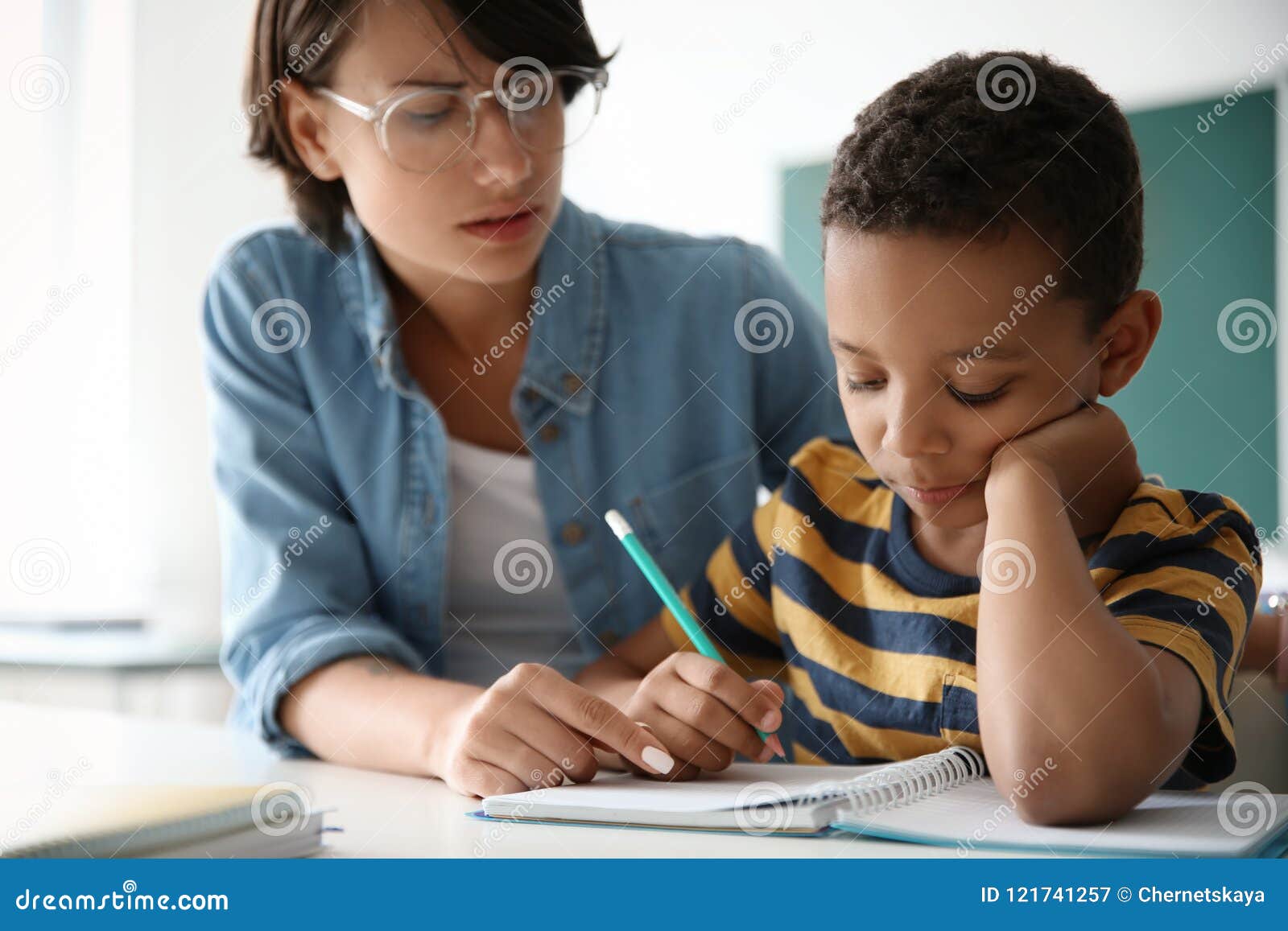 Female Teacher Helping Child With Assignment Stock Image - Image of ...