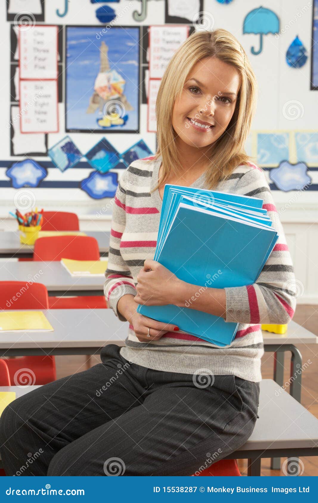 Female Teacher Sitting at Desk in Classroom Stock Image - Image of ...