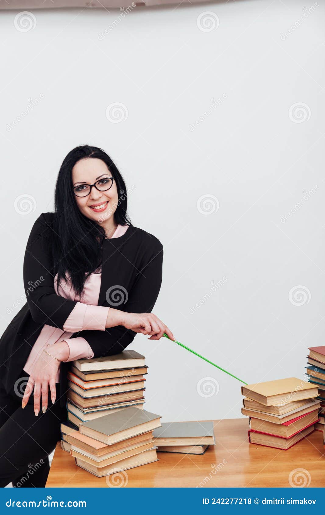 Female Teacher at a Table with Books in the University Library Stock ...