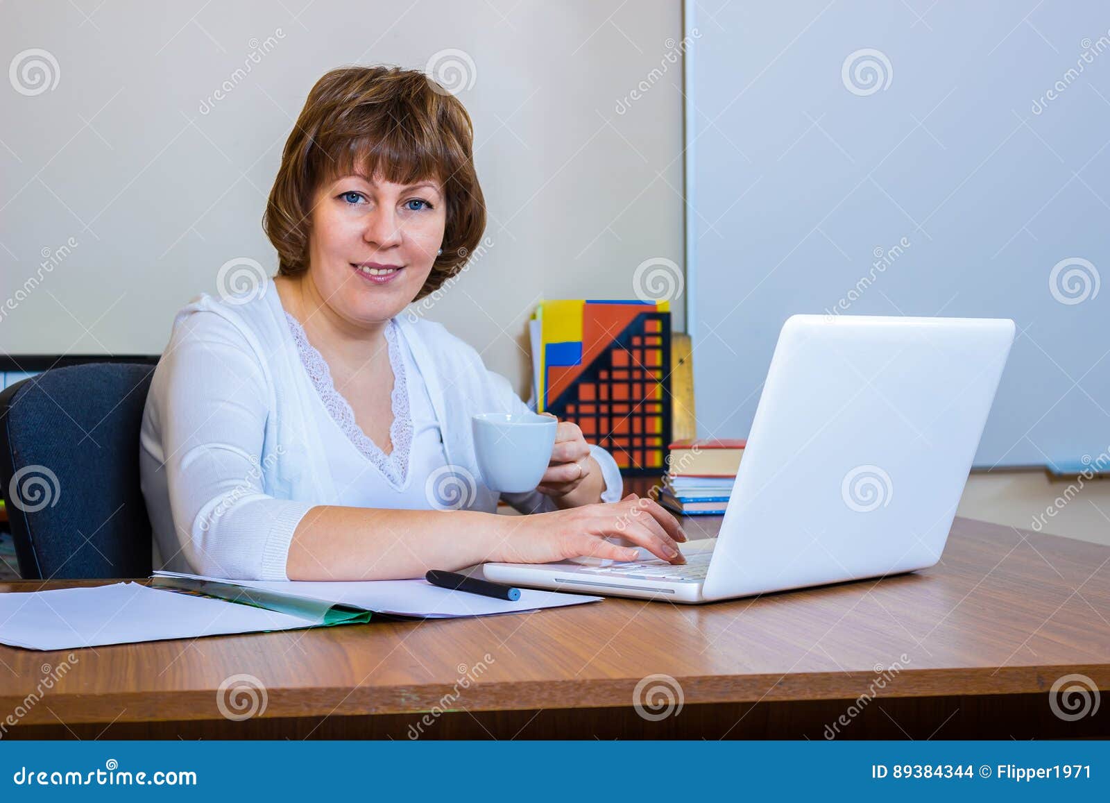 A Female Teacher at a Table in the Classroom Stock Photo - Image of ...