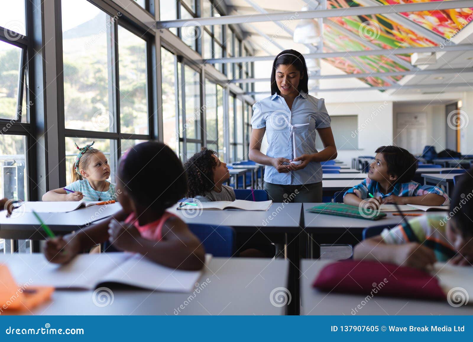 Female Teacher Teaching Student at Desk in Classroom Stock Image ...