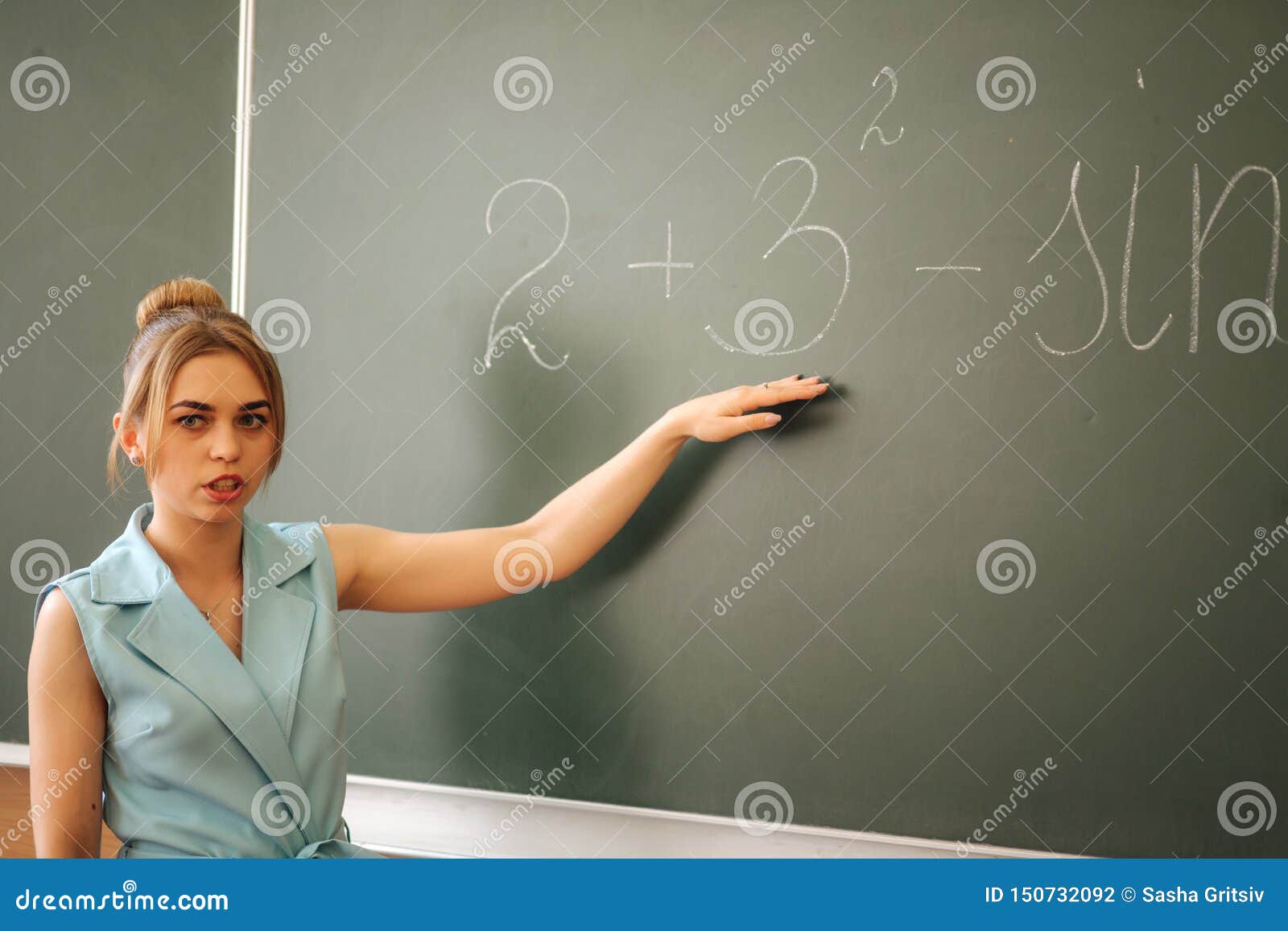 Female Teacher Whiting Thomething on School Desk. Young Teacher Stock ...