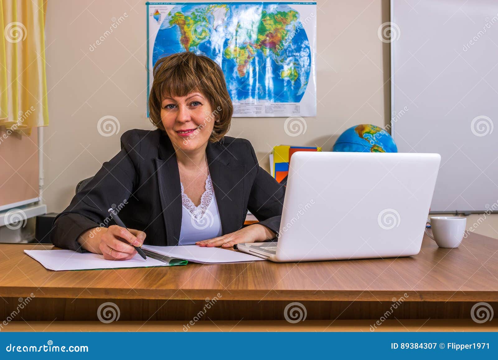 A Female Teacher Works at a Computer in the Classroom Stock Image ...