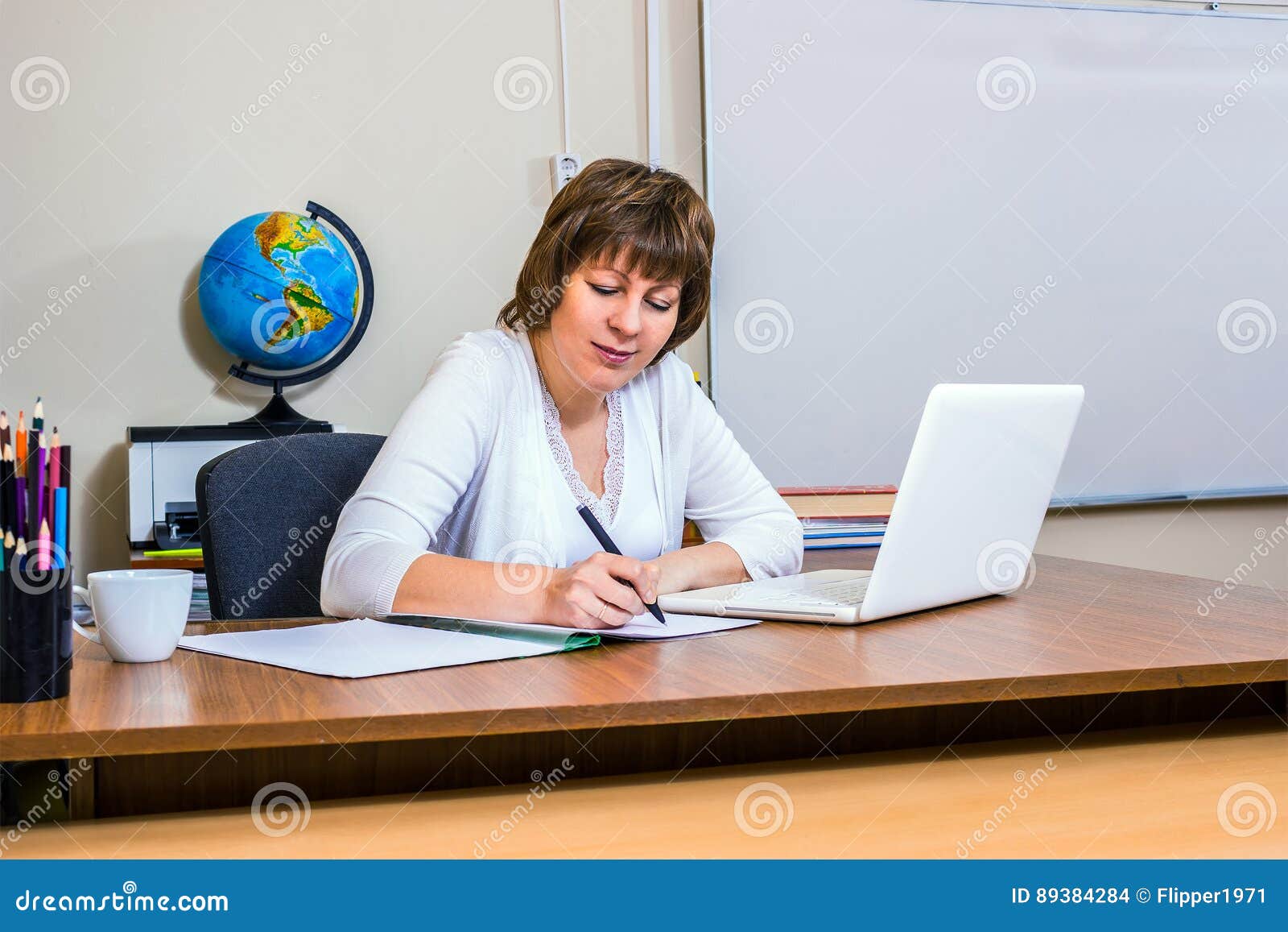 A Female Teacher Works with a Laptop in the Classroom Stock Photo ...