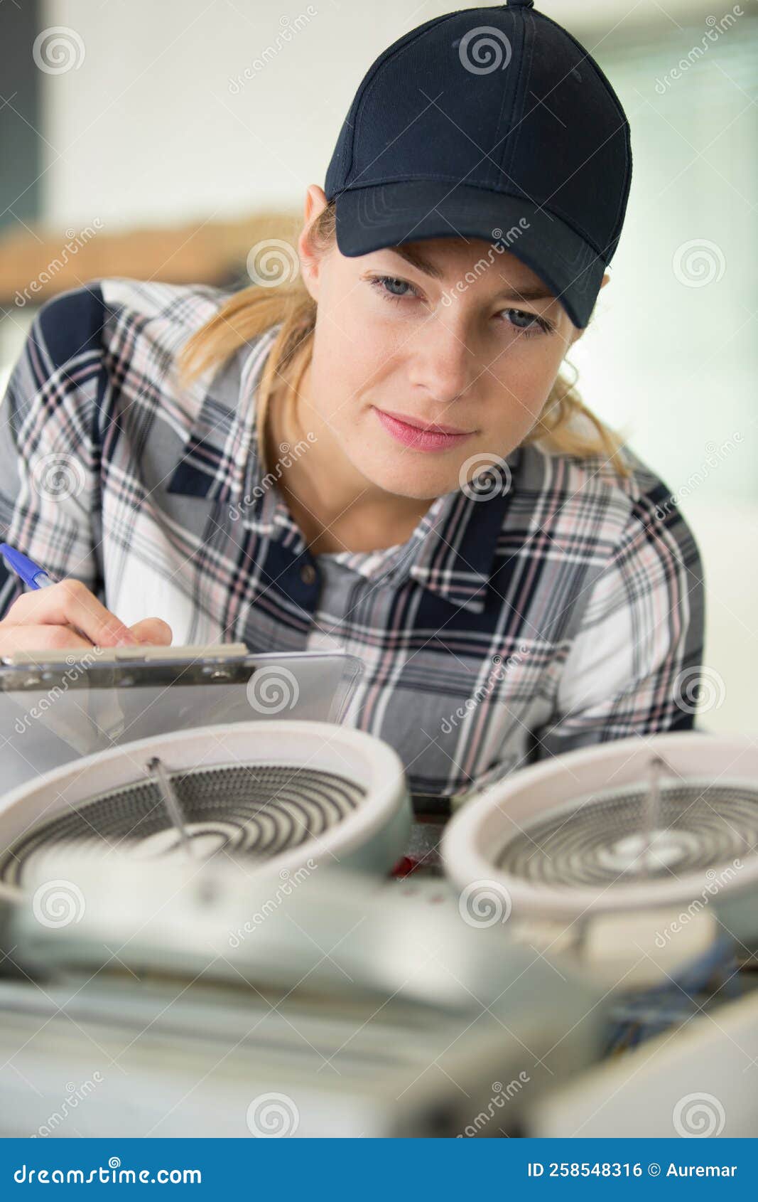 Female Technician Checking Electric Device and Taking Notes Stock Photo ...