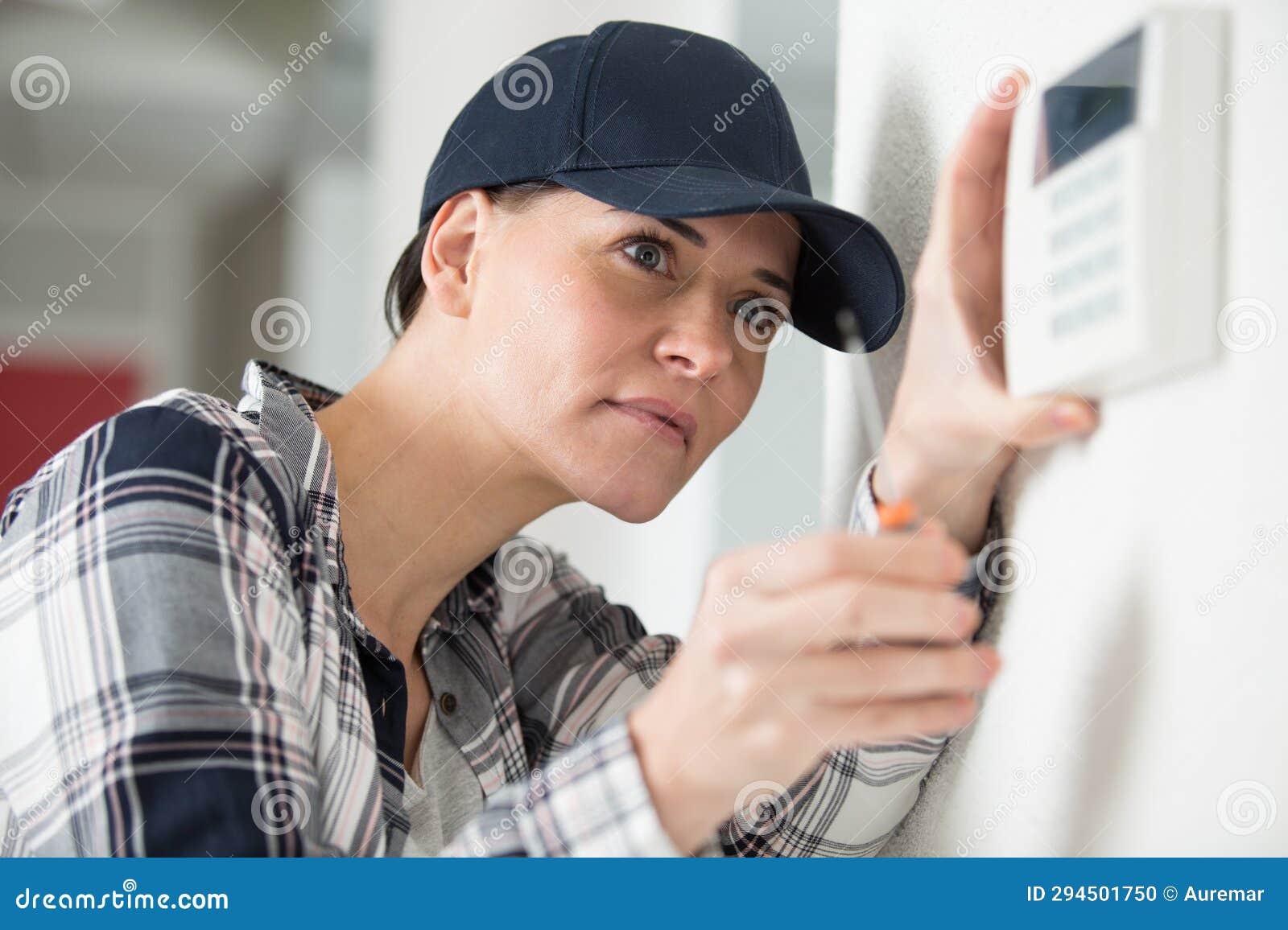 Female Technician Installing Security System on Wall Stock Photo ...