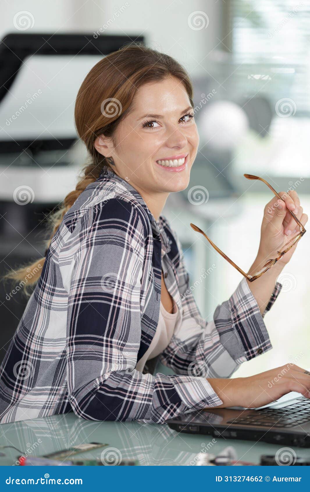 Female Technician Using Laptop and Holding Eyeglasses Stock Photo ...