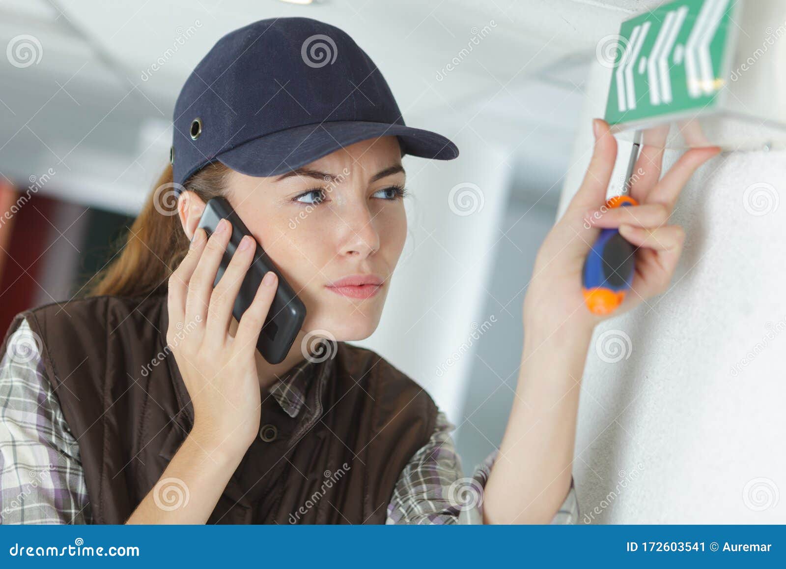 Female Technician Using Smart Phone Emergency Exit Stock Image - Image ...